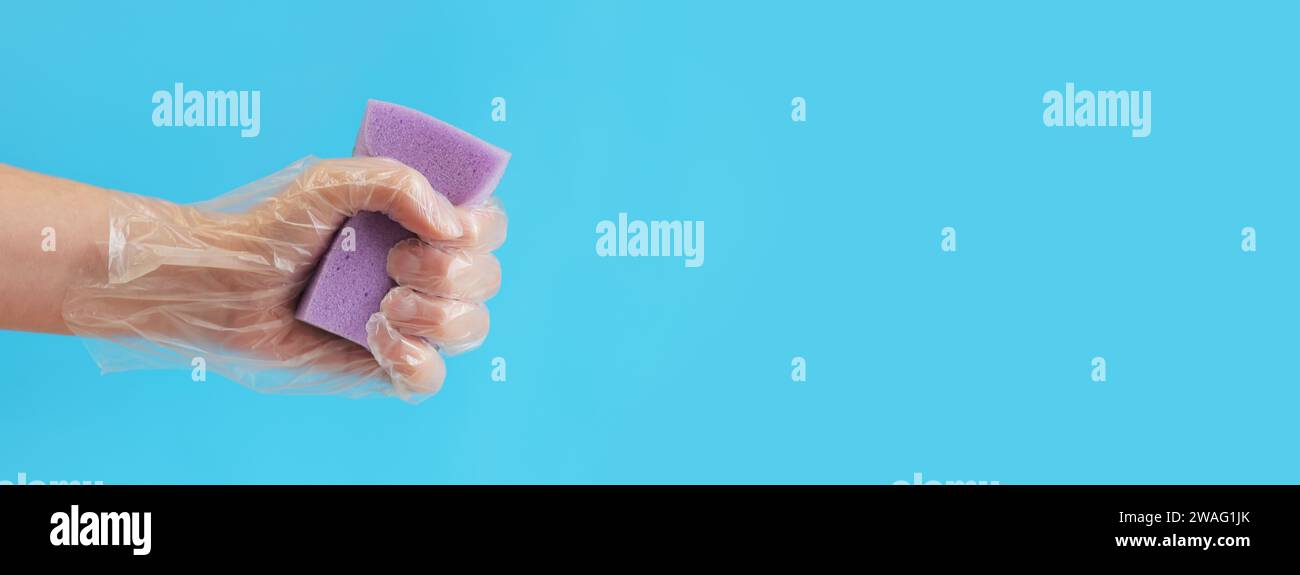 Hand and sponge for washing dishes. A hand in a glove with a sponge for ...