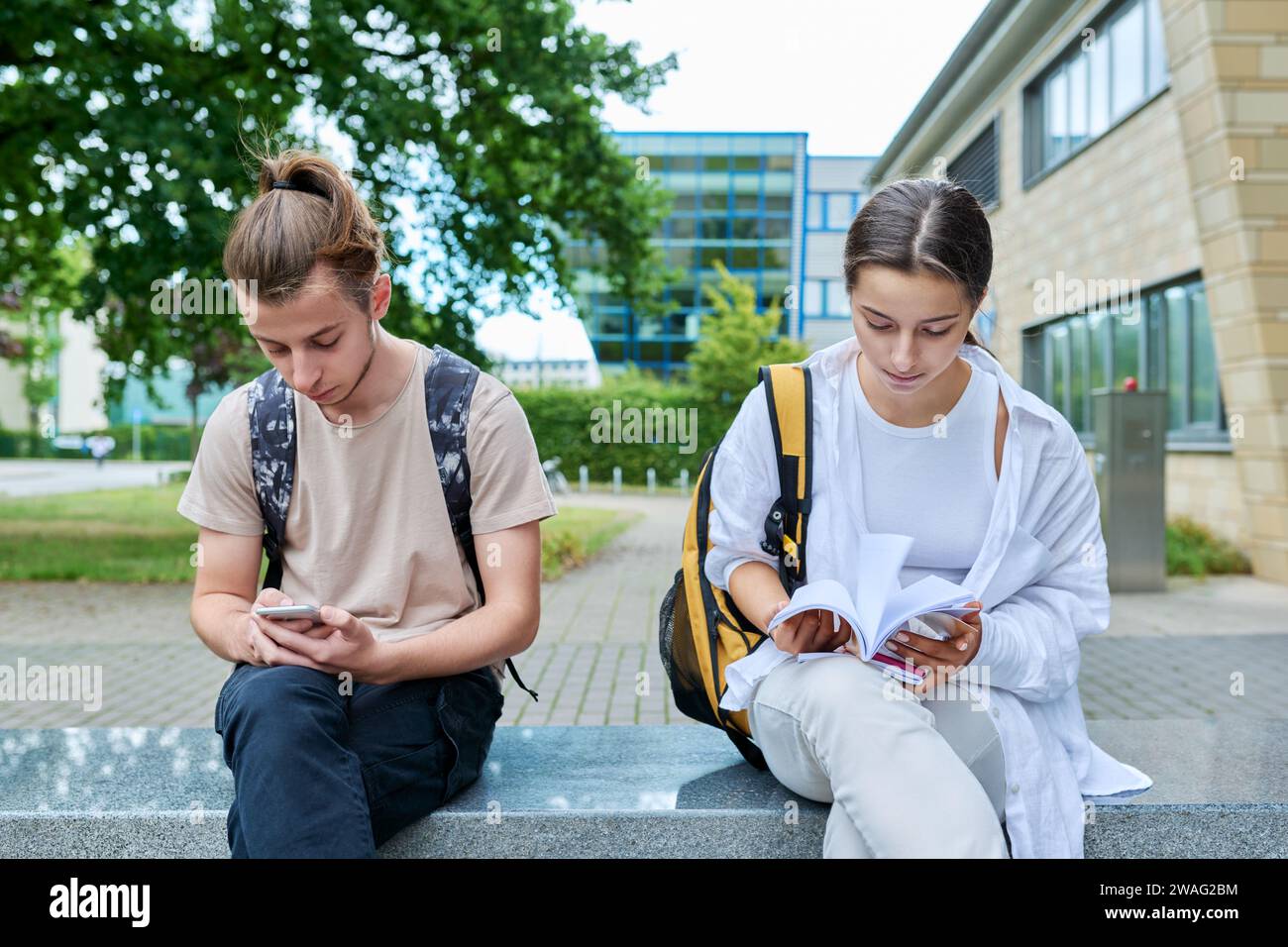Two high school students guy and girl outdoor, school building ...
