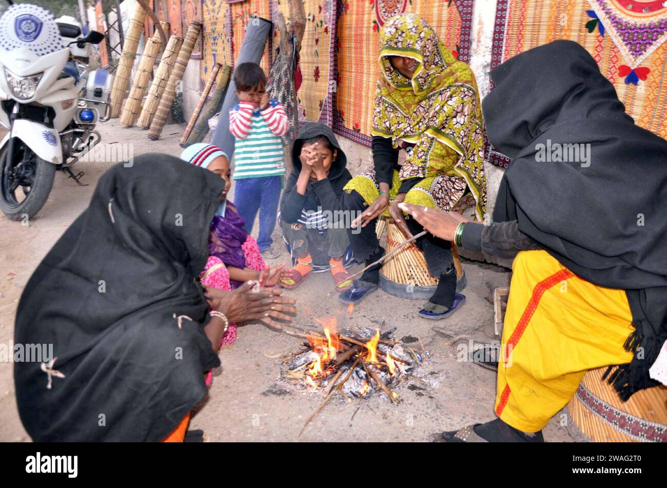 People warm their hands on bone-fire to save themselves from cold waves ...