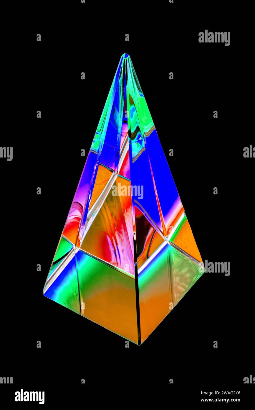 Glass pyramid prism with colorful light reflection on black background ...
