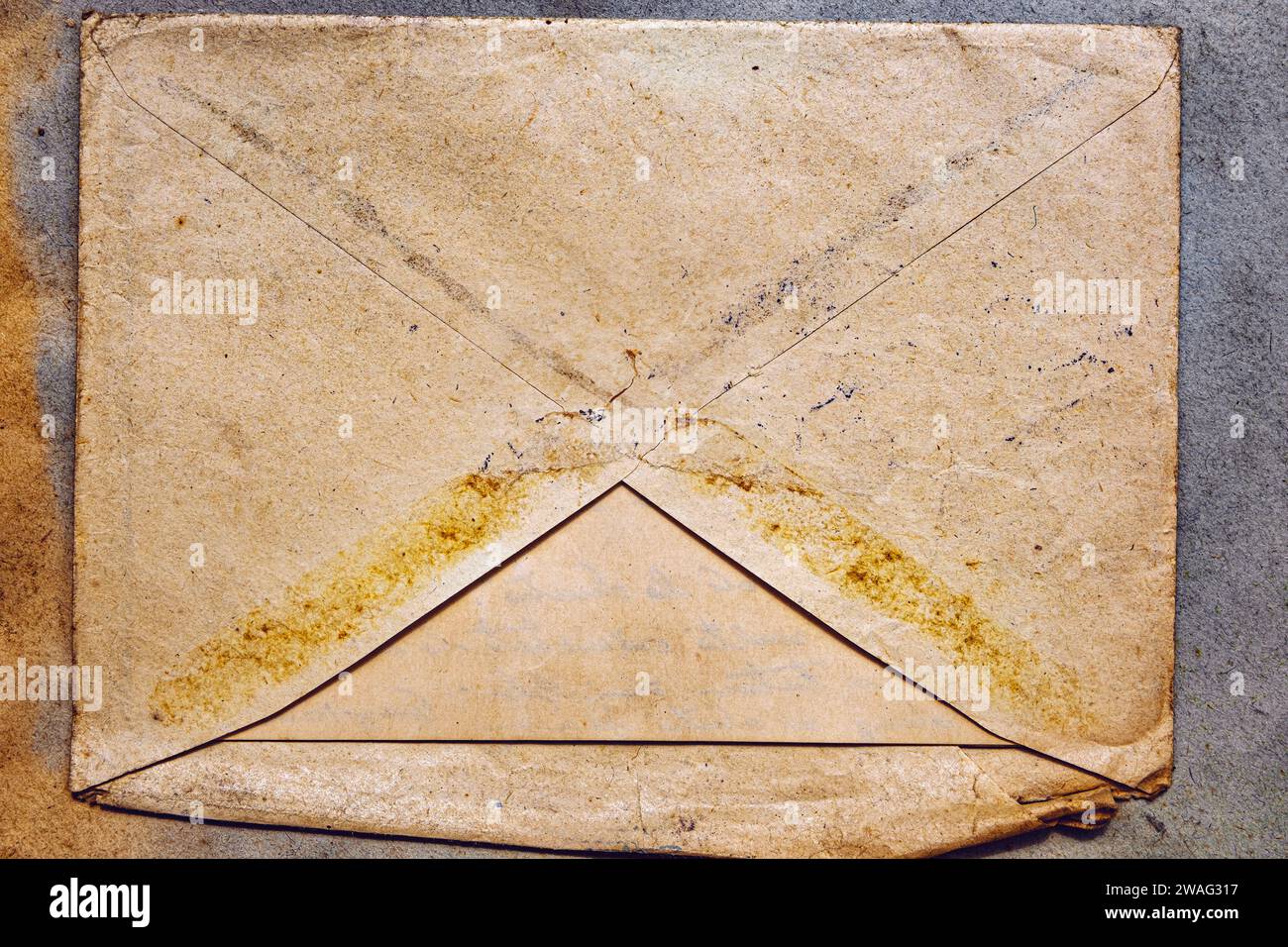 front view closeup of blank old aged closed letter paper envelope with torn edges from 1900 ...