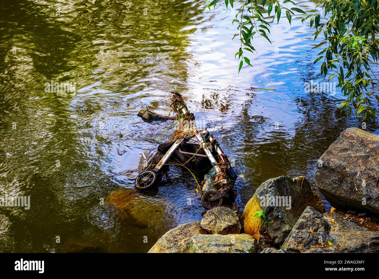 Ruined baby stroller abandoned in the river. Environmental pollution ...