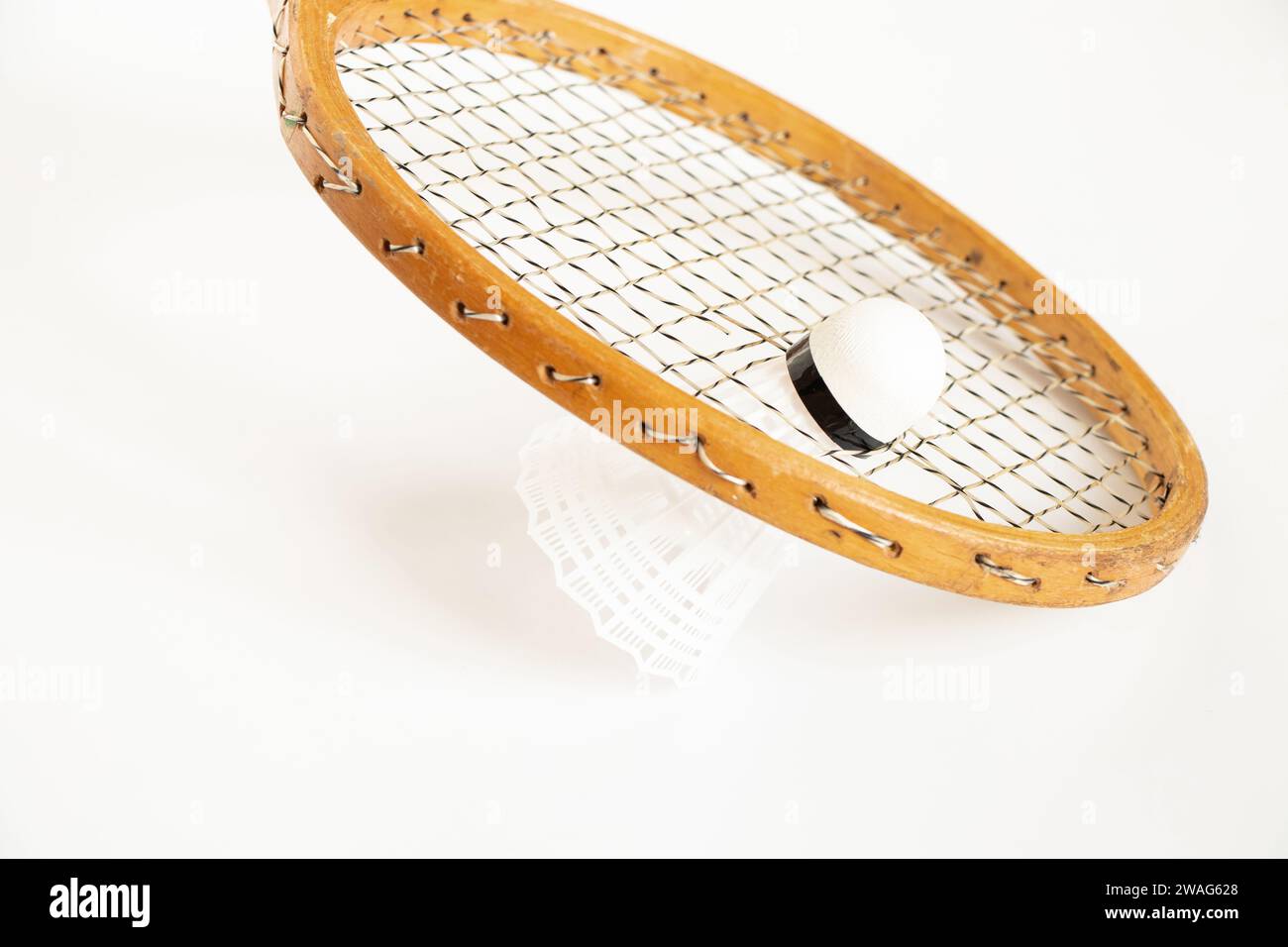Old wooden racket and shuttlecock closeup on a white background, sport ...