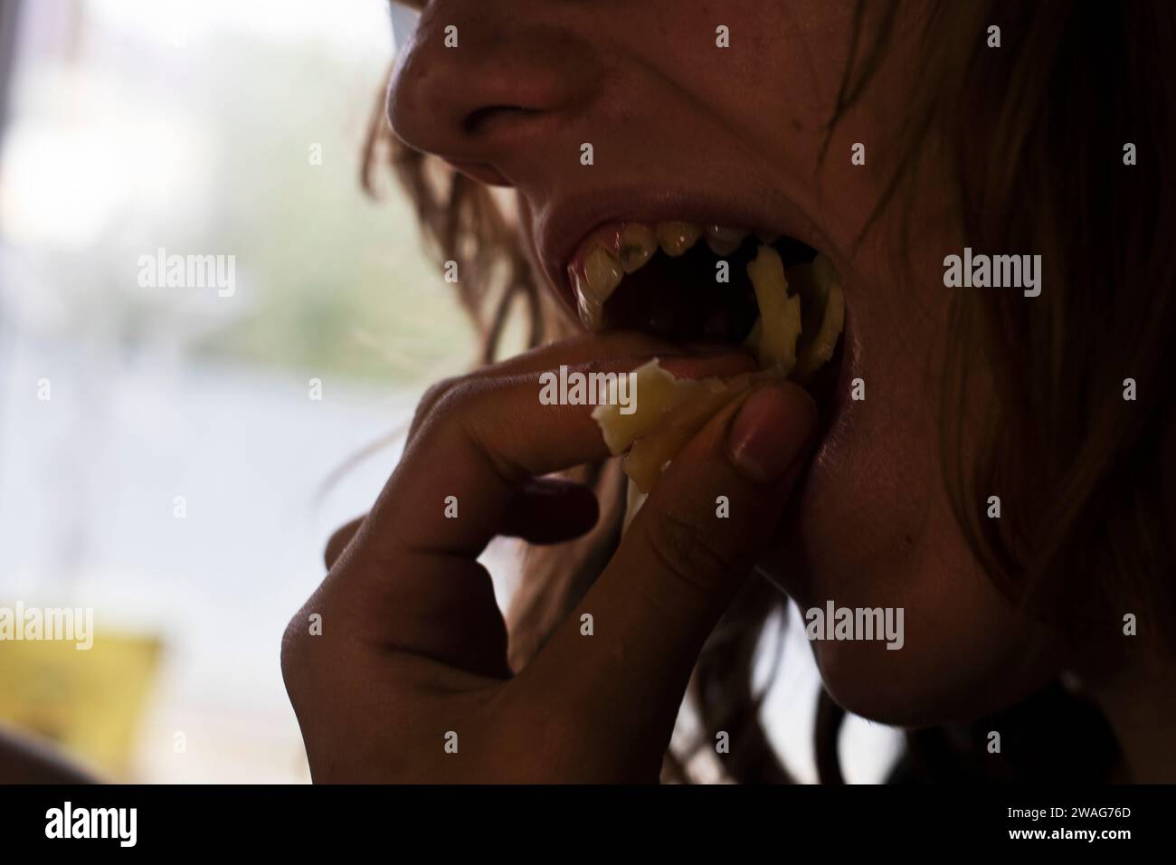 young girls take hard cheese, thinly sliced, and eat it with their ...
