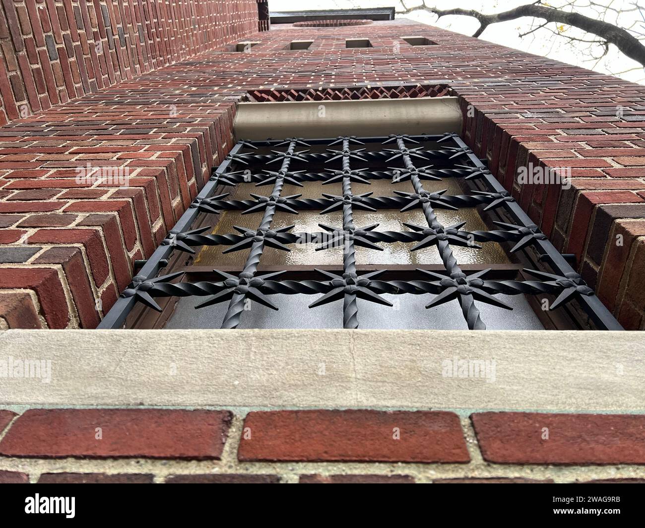 A red brick building with a metal window guard Stock Photo - Alamy