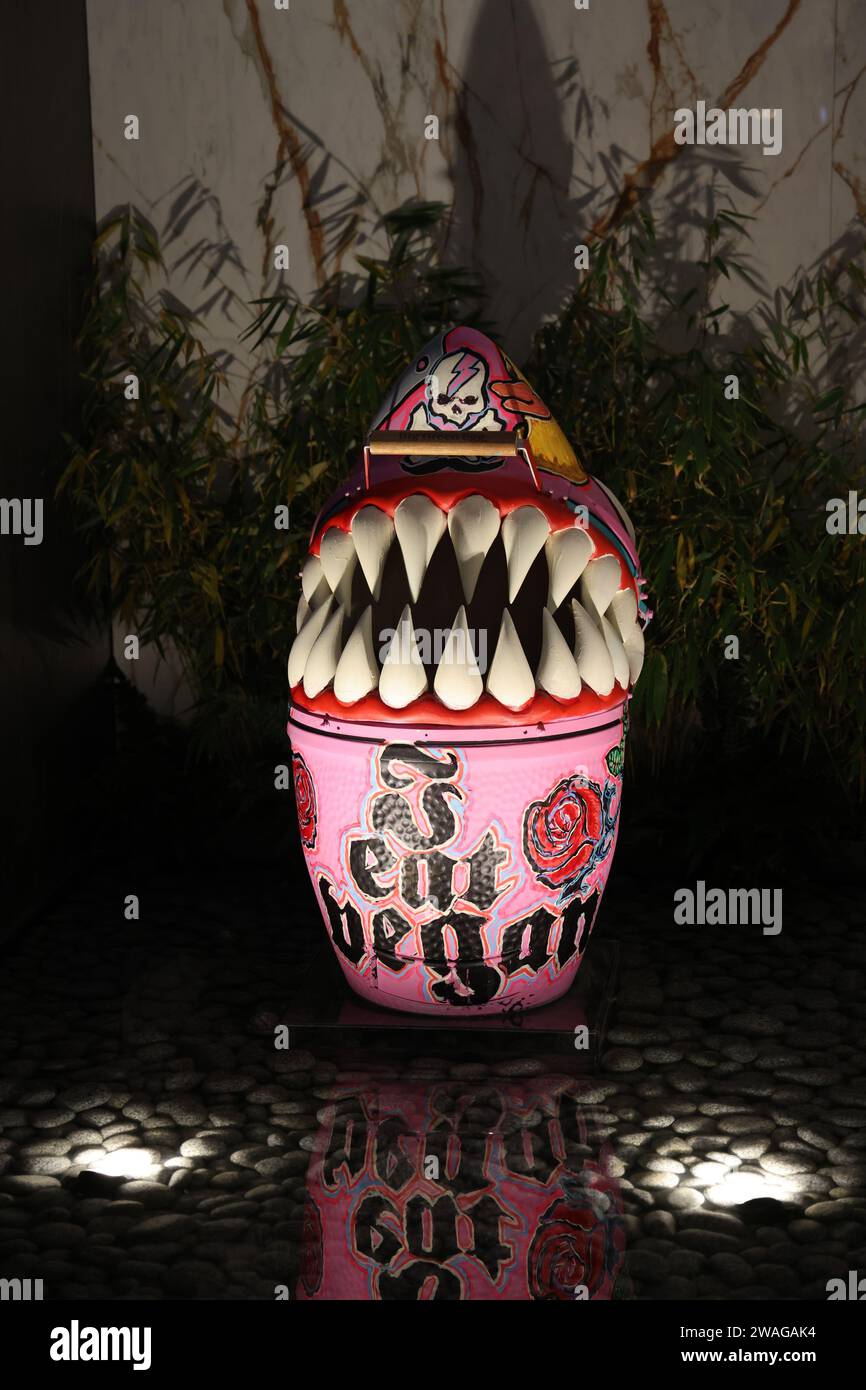 A Big Green Egg decorated as artwork with skull, sharp teeth and text "Eat Vegan", exhibited at ...