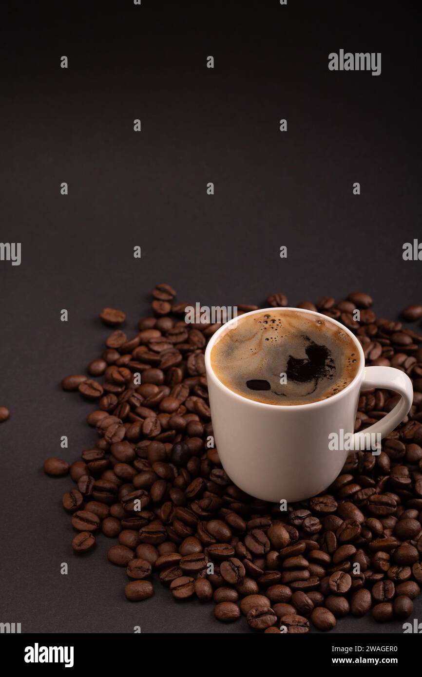 photo presents a cup of espresso surrounded by aromatic coffee beans ...