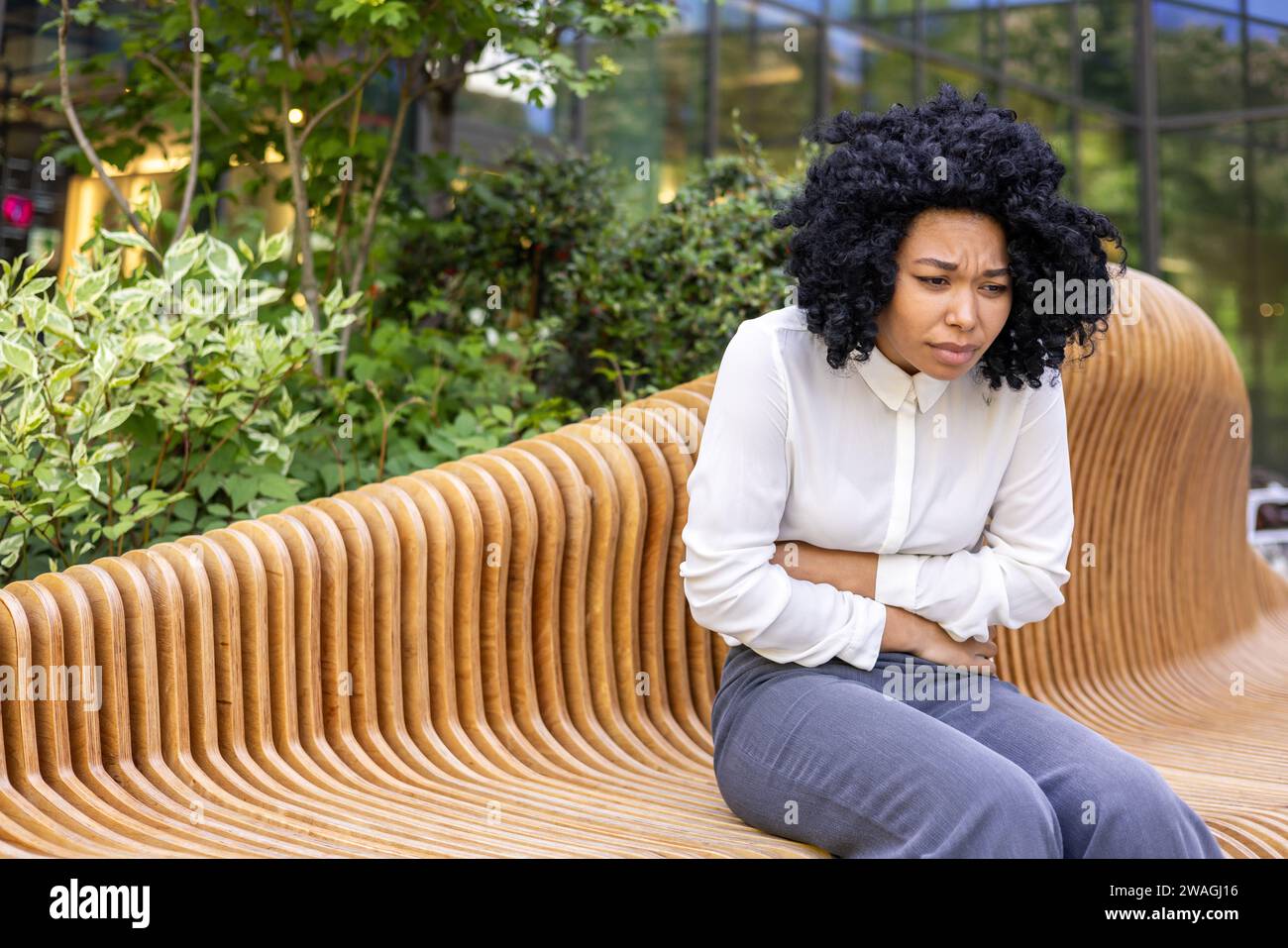 Tired overworked woman sitting on bench outside office building after ...