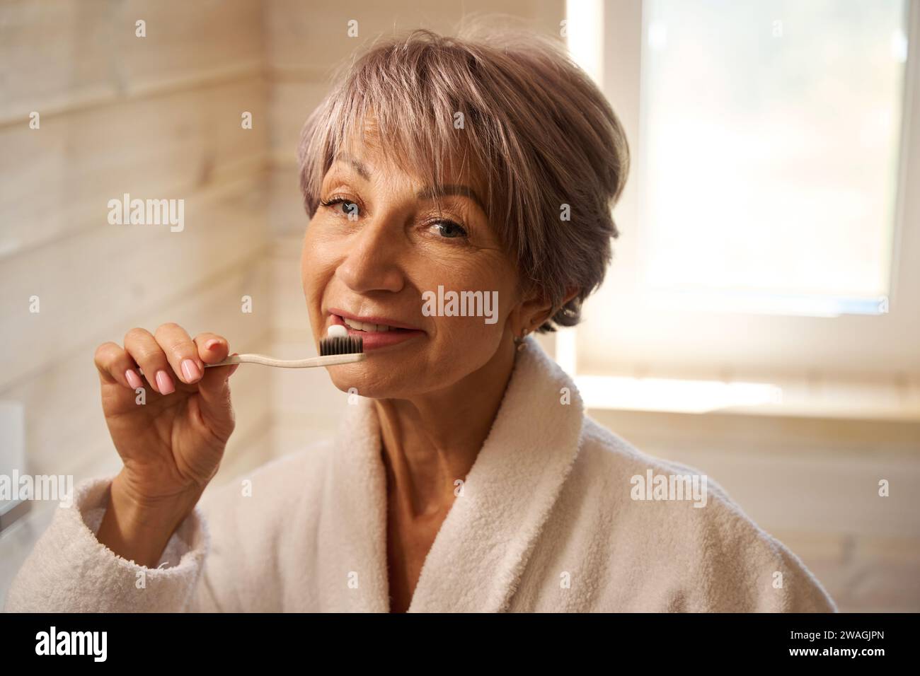 Elderly lady brushes her teeth with a toothbrush and toothpaste Stock ...