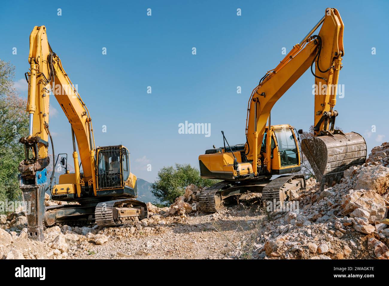 Two Yellow Excavators on Construction Site with Rocky Terrain Stock ...
