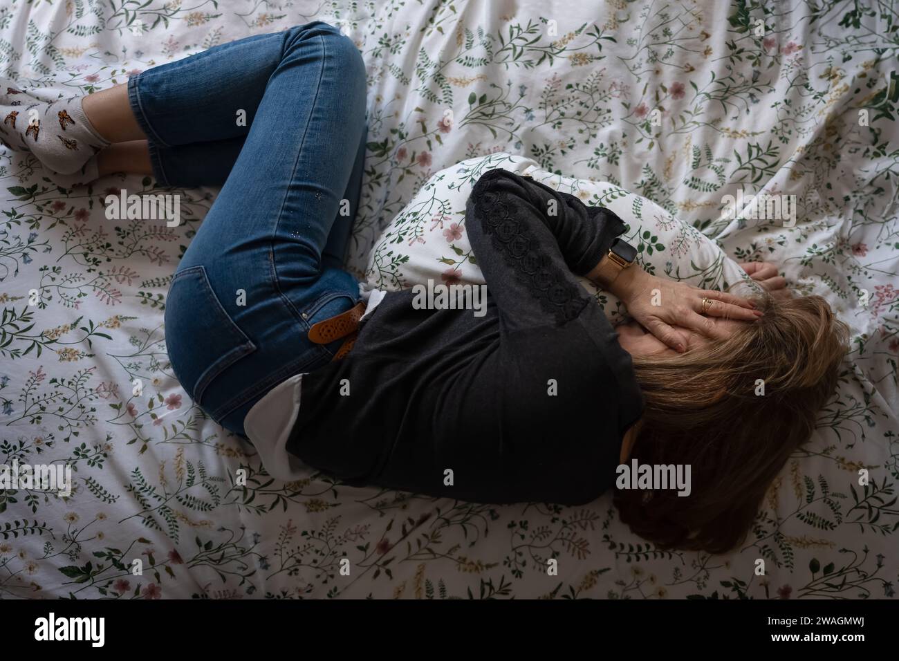 Woman curled in bed hi-res stock photography and images - Alamy