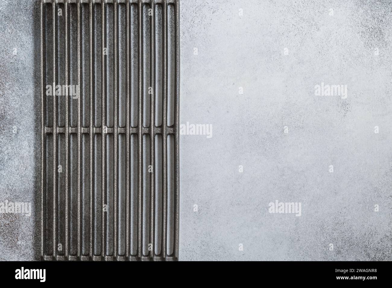 Iron grill grid or BBQ grate on plaster background with copy space ...