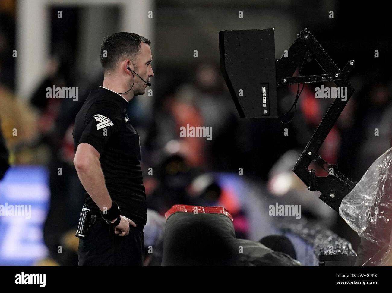 Referee Chris Kavanagh views the VAR monitor before showing a red card ...