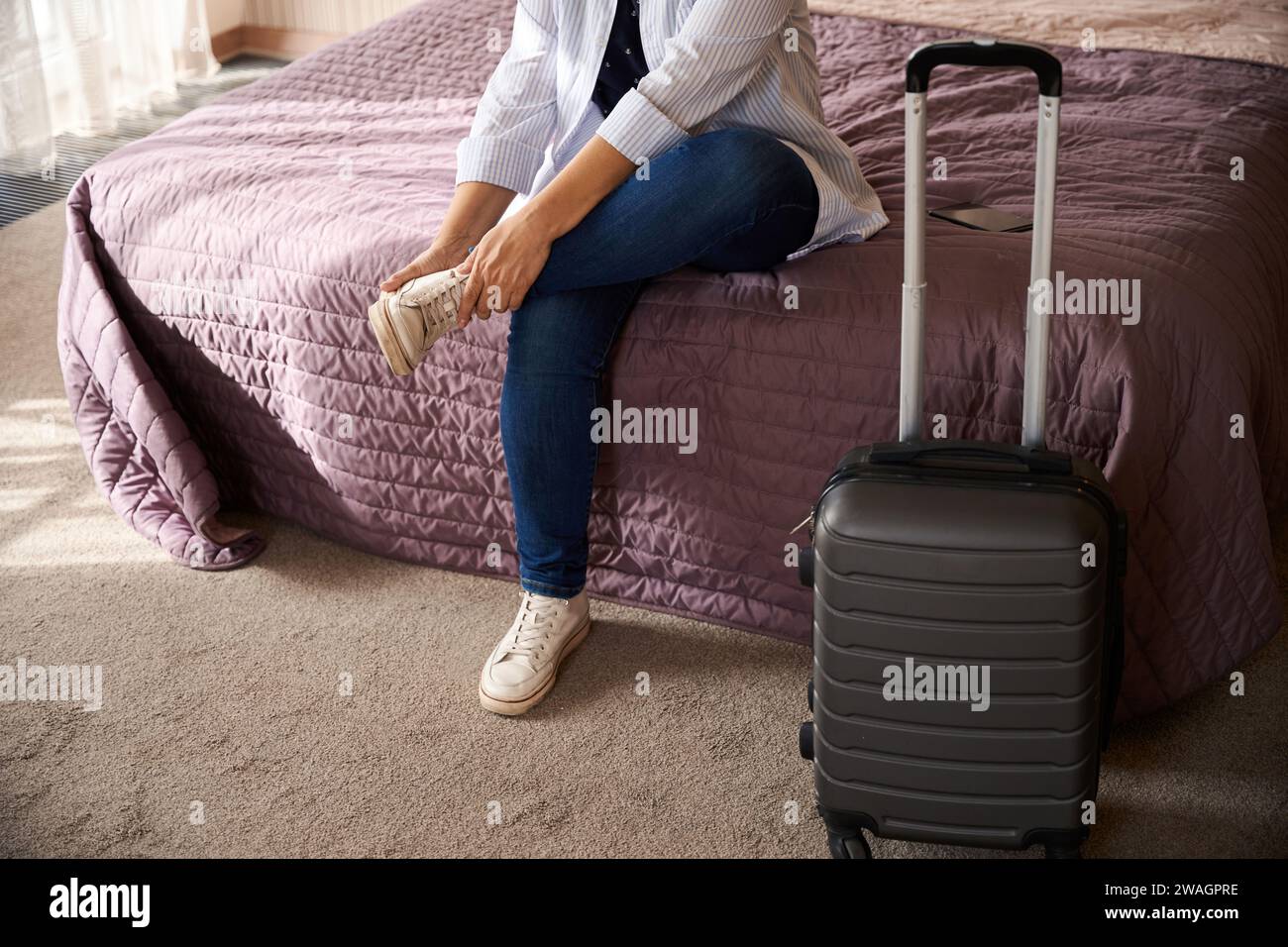 Traveler taking off sneakers after arrival in suite Stock Photo - Alamy
