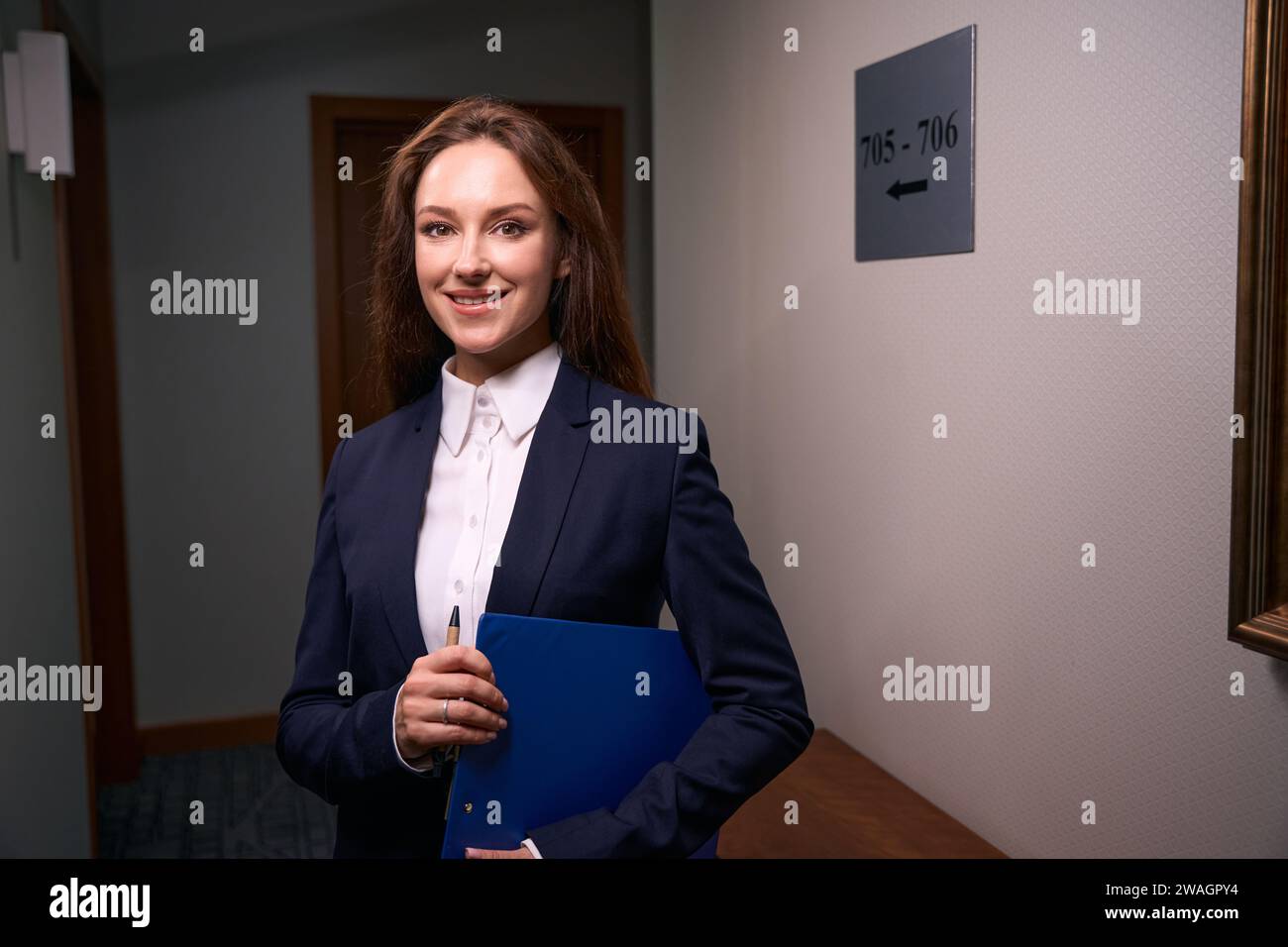 Joyous housekeeping supervisor posing for camera before conducting room ...
