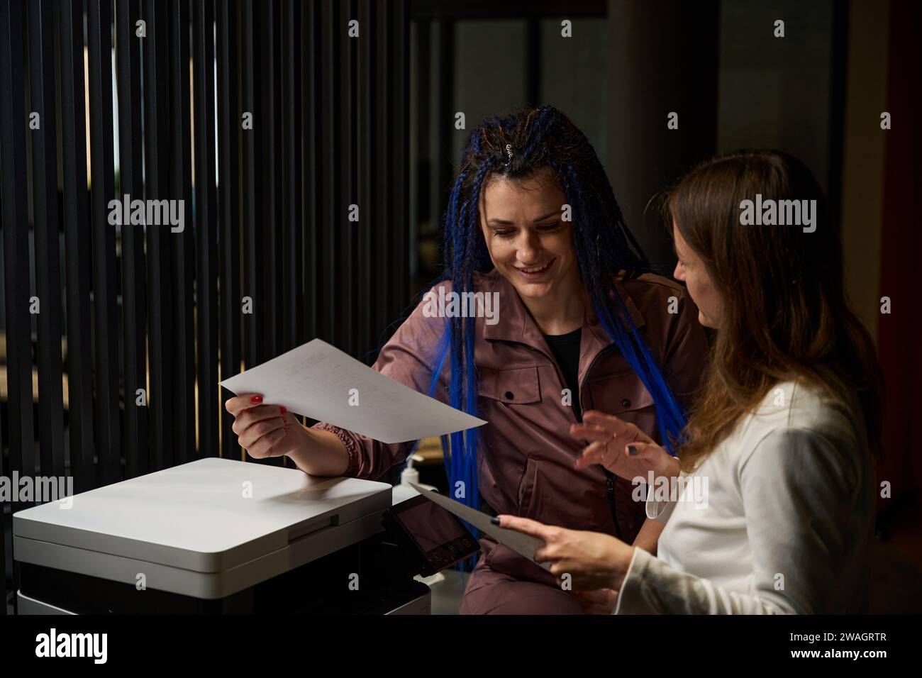 Female colleagues making copies of private documents of office ...