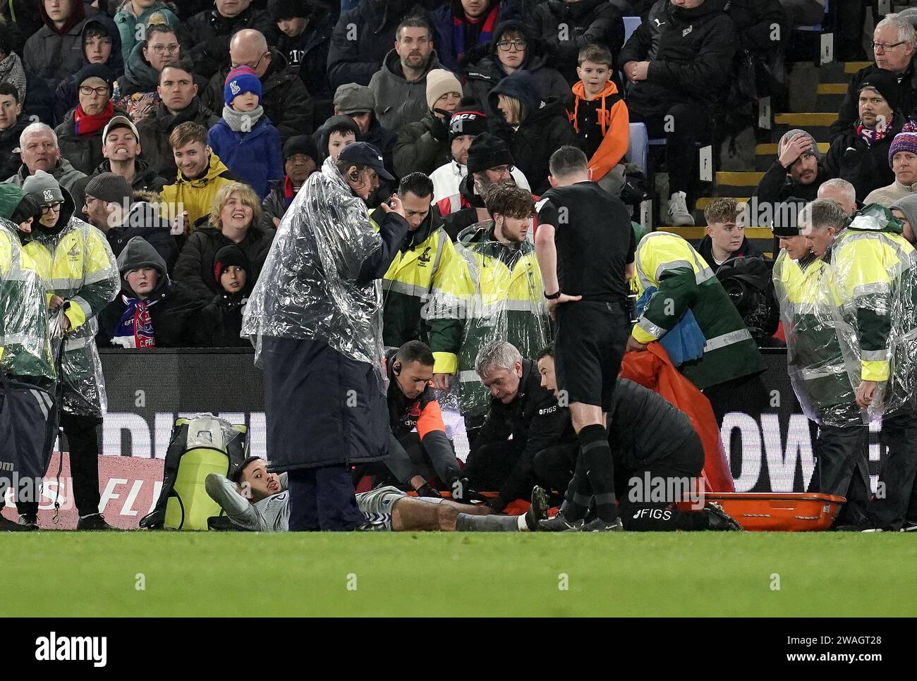 Everton's Dwight McNeil receives treatment before leaving the game on a ...