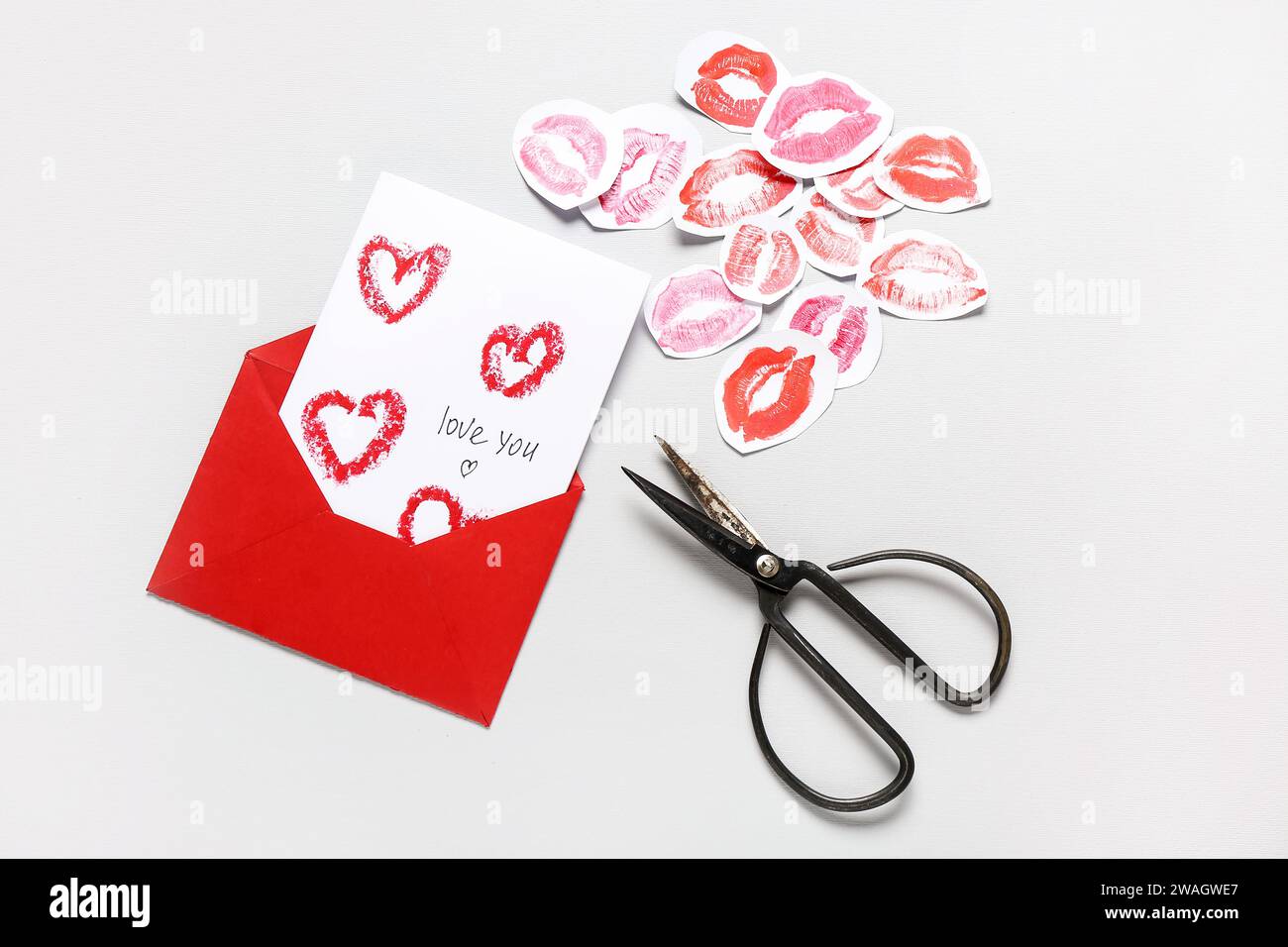 Envelope, card with text LOVE YOU, lipstick kiss marks and scissors on ...