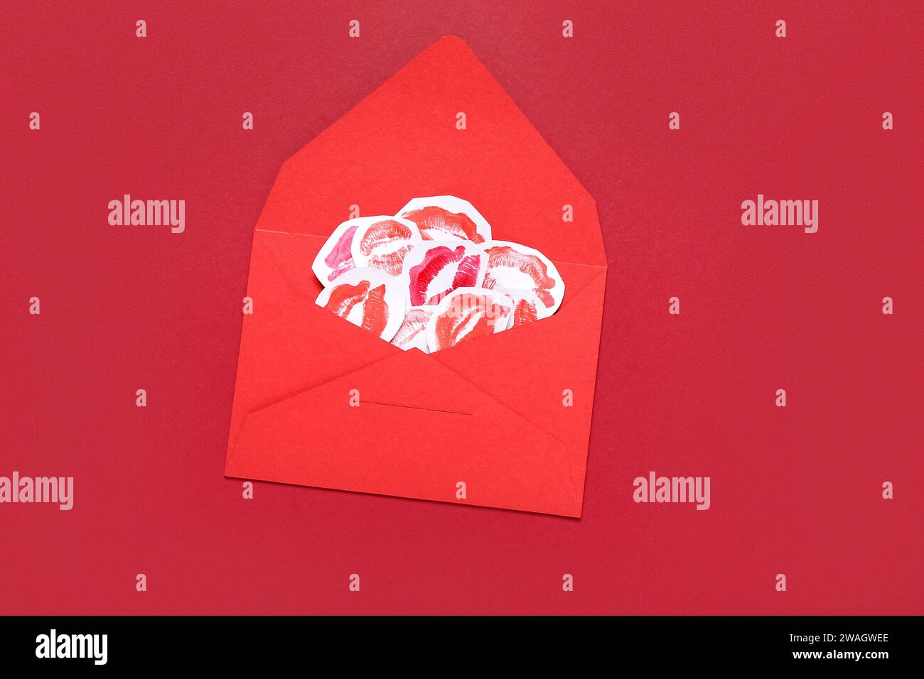 Red envelope with paper lipstick kiss marks on color background ...