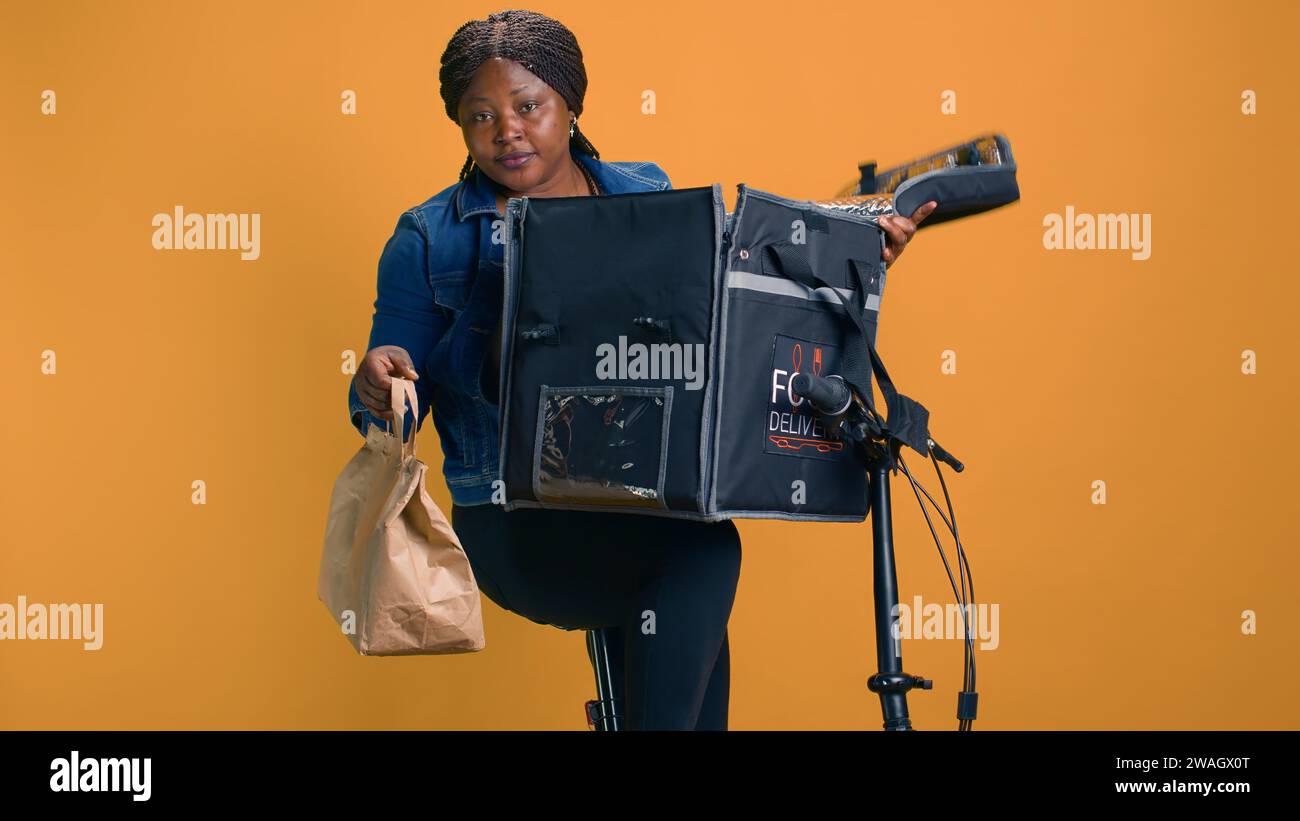African american woman grabbing takeaway from food delivery bag for ...