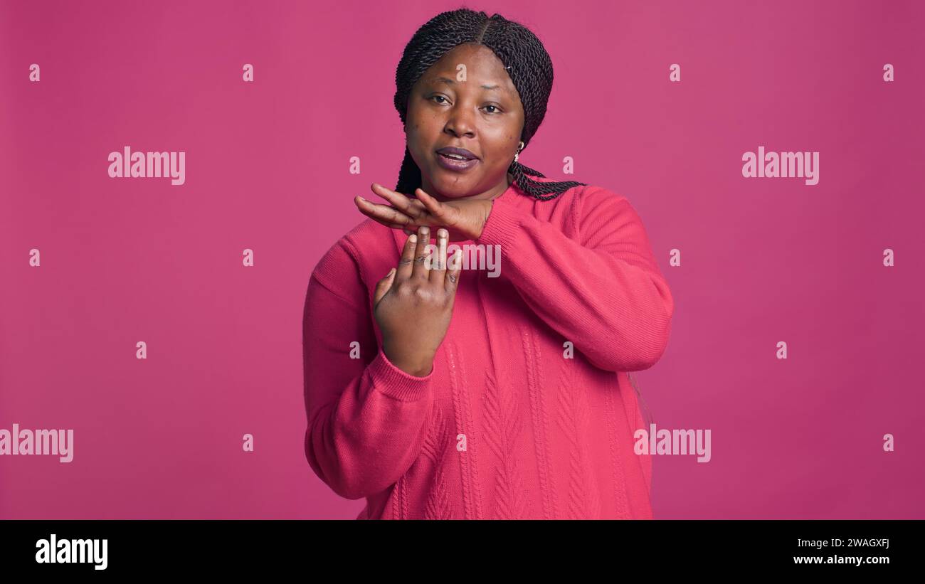 Expressive young black woman showing time-out sign using her hands in ...