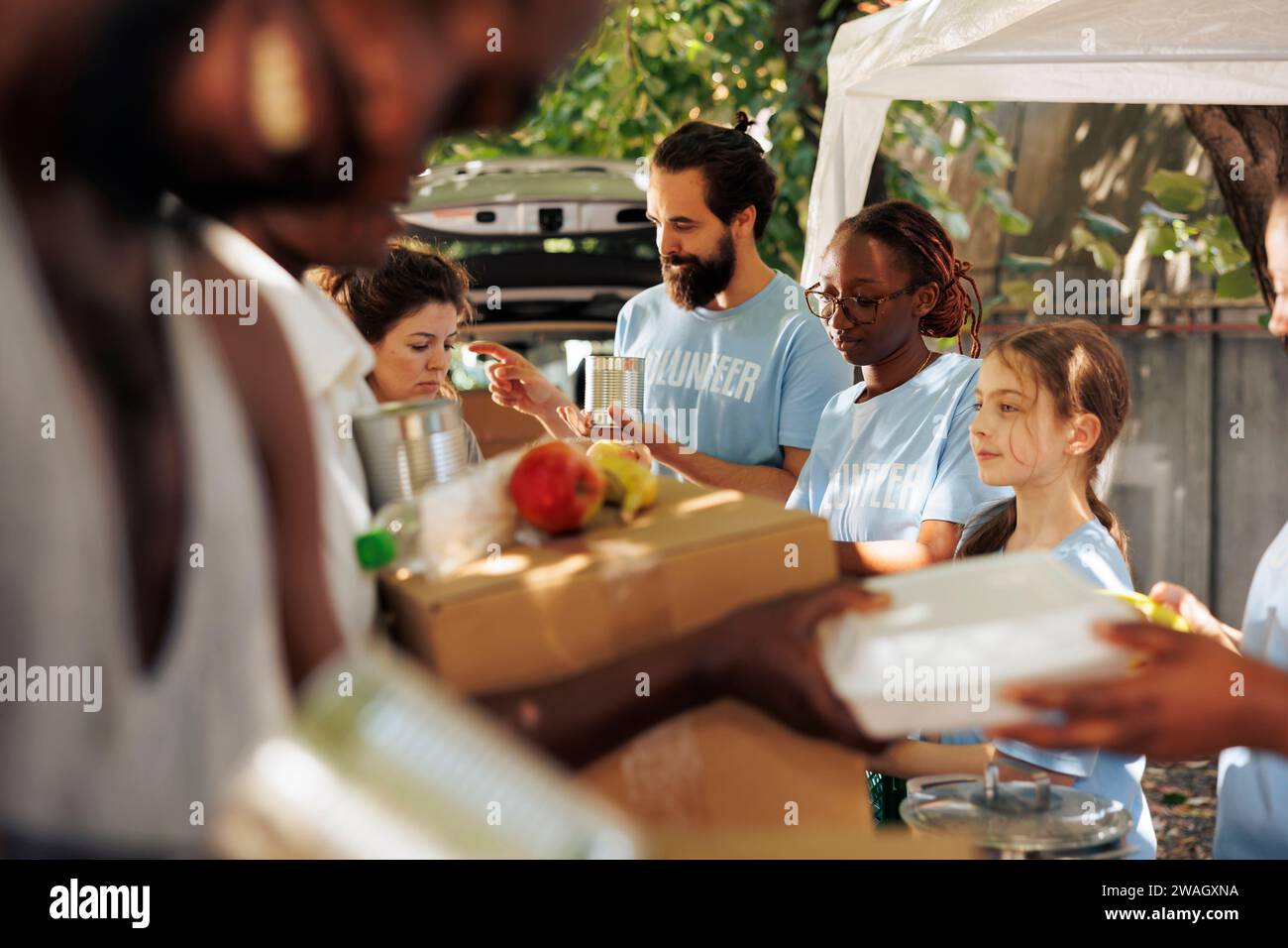 African American and Caucasian individuals distribute food and supplies ...