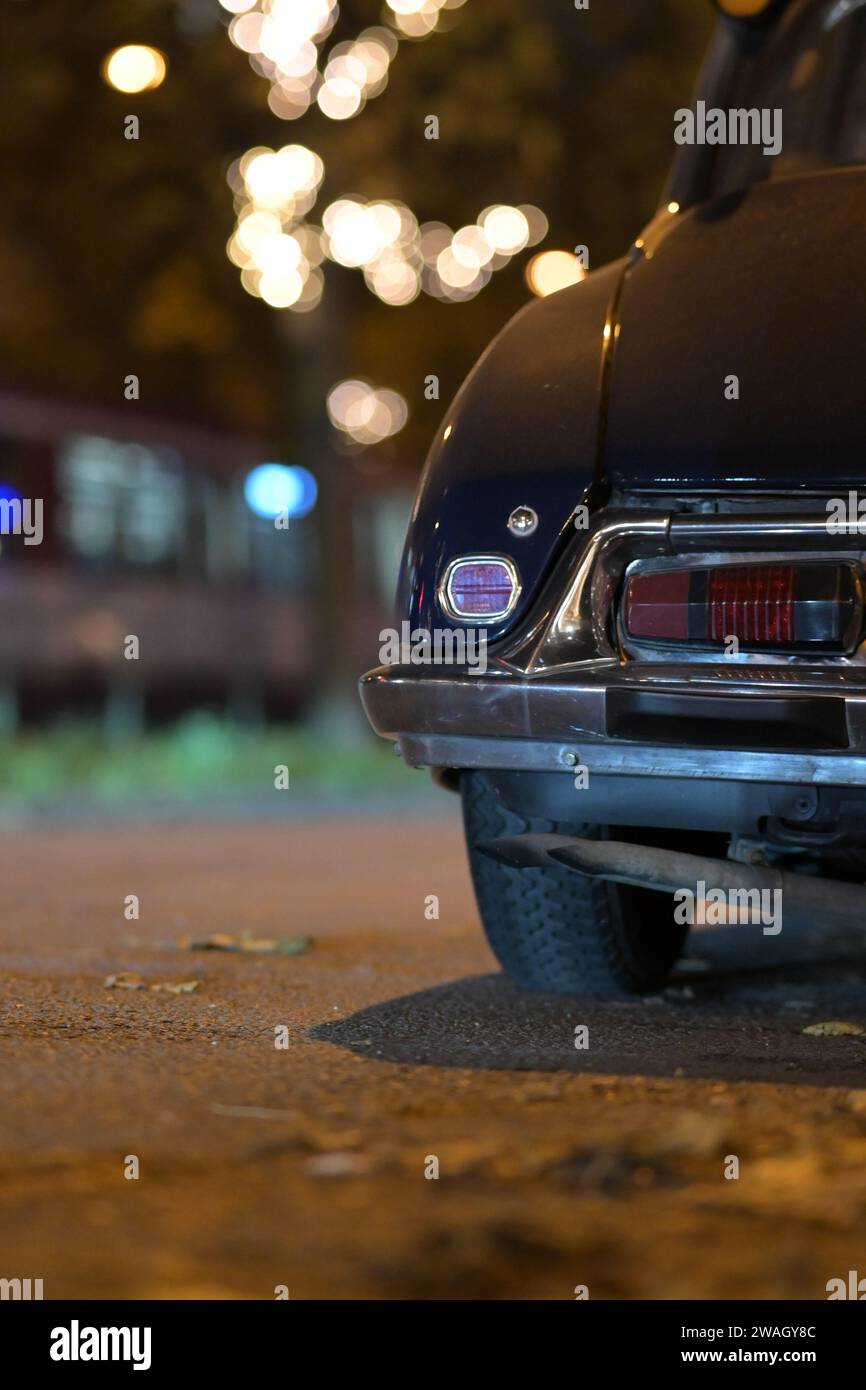Black french classic car parked in front of other cars at night in ...