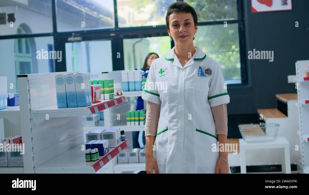 Portrait of friendly pharmacist in apothecary placing cardiovascular ...