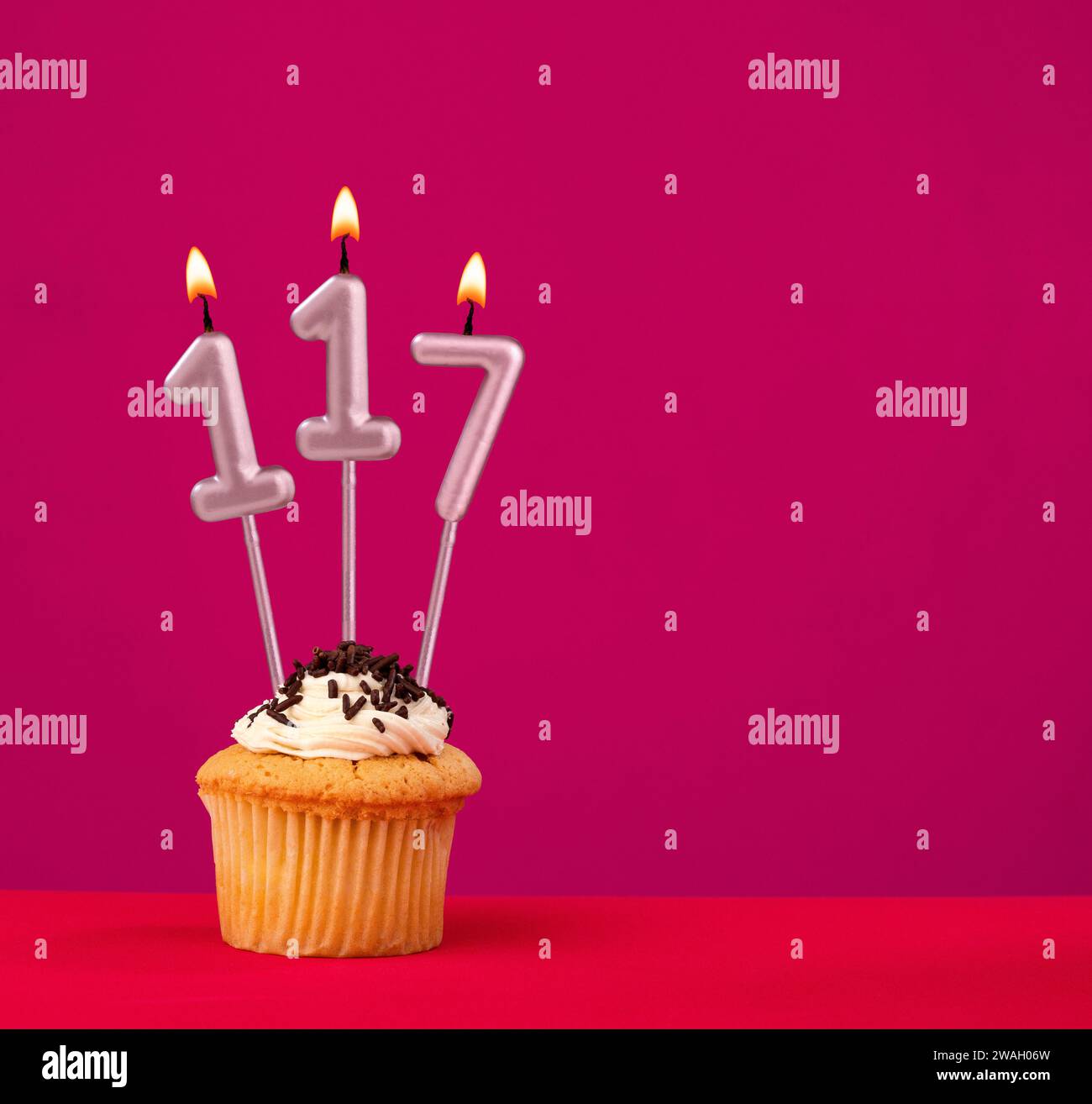 Birthday cake with candle number 117 - Rhodamine Red foamy background ...