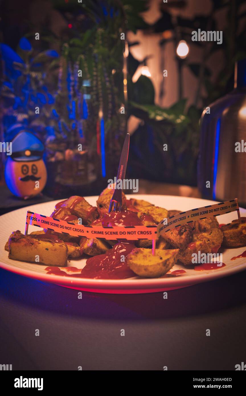 Potato dressed as a policeman in front of a plate with potato wedges ...