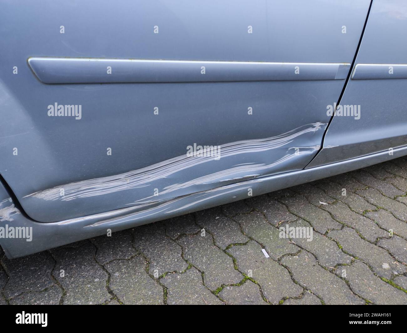 Blue car door with a very large scratch after hitting a wall Stock ...