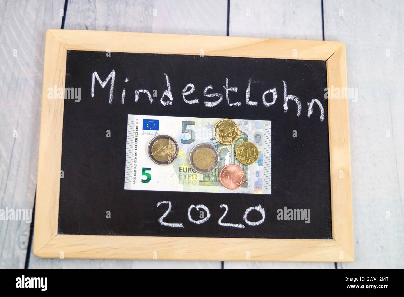 Euro note and euro coins, 9.35 euro minimum wage 2020 on a blackboard ...
