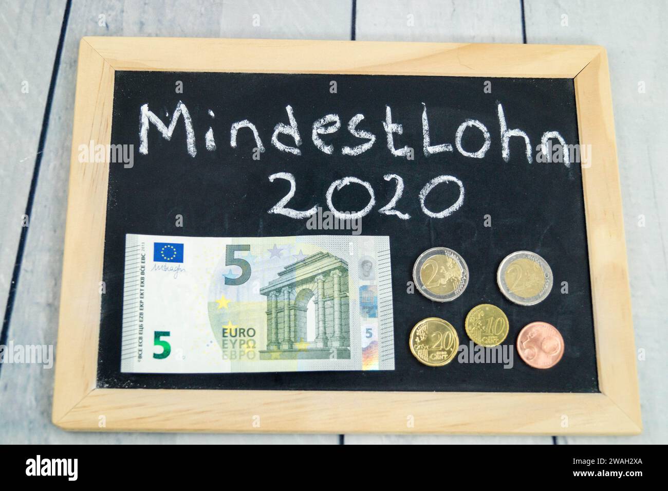 Euro note and euro coins, 9.35 euro minimum wage 2020 on a blackboard ...