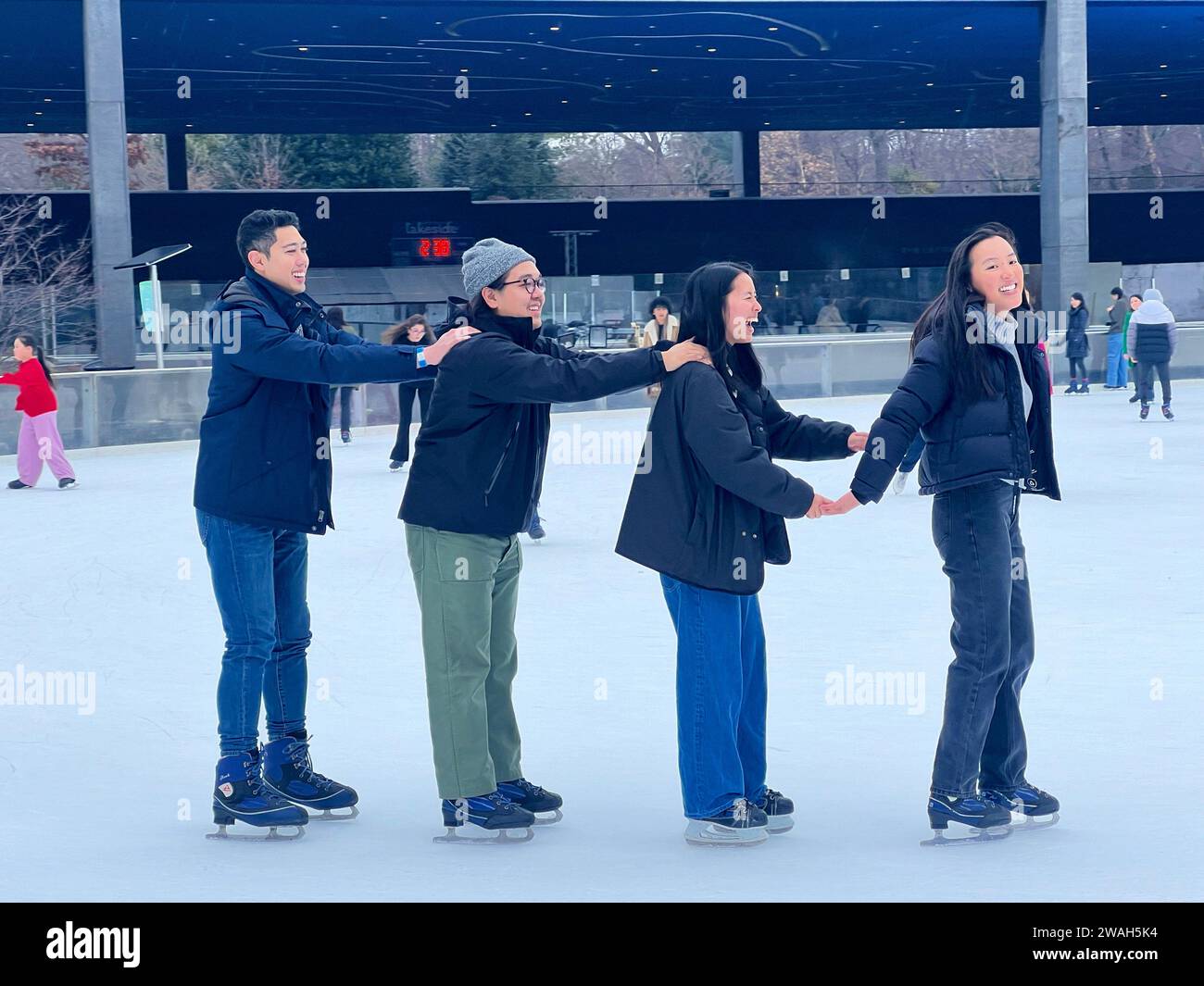Group of friends having fun on the ice skating rink in Prospect Park ...