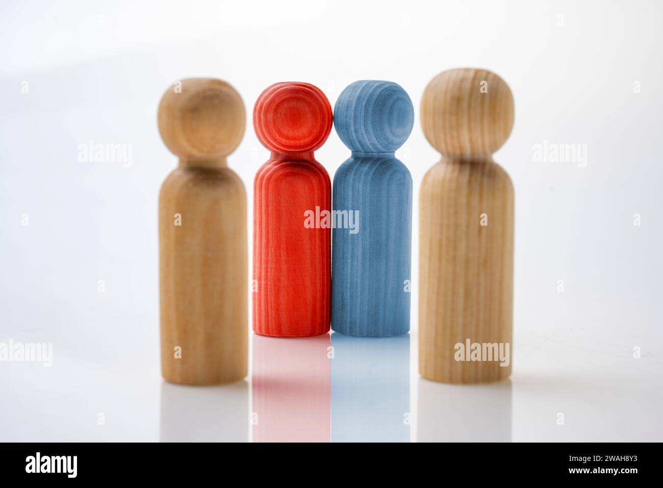 Red and blue wooden figures stand out from the four wooden figures ...