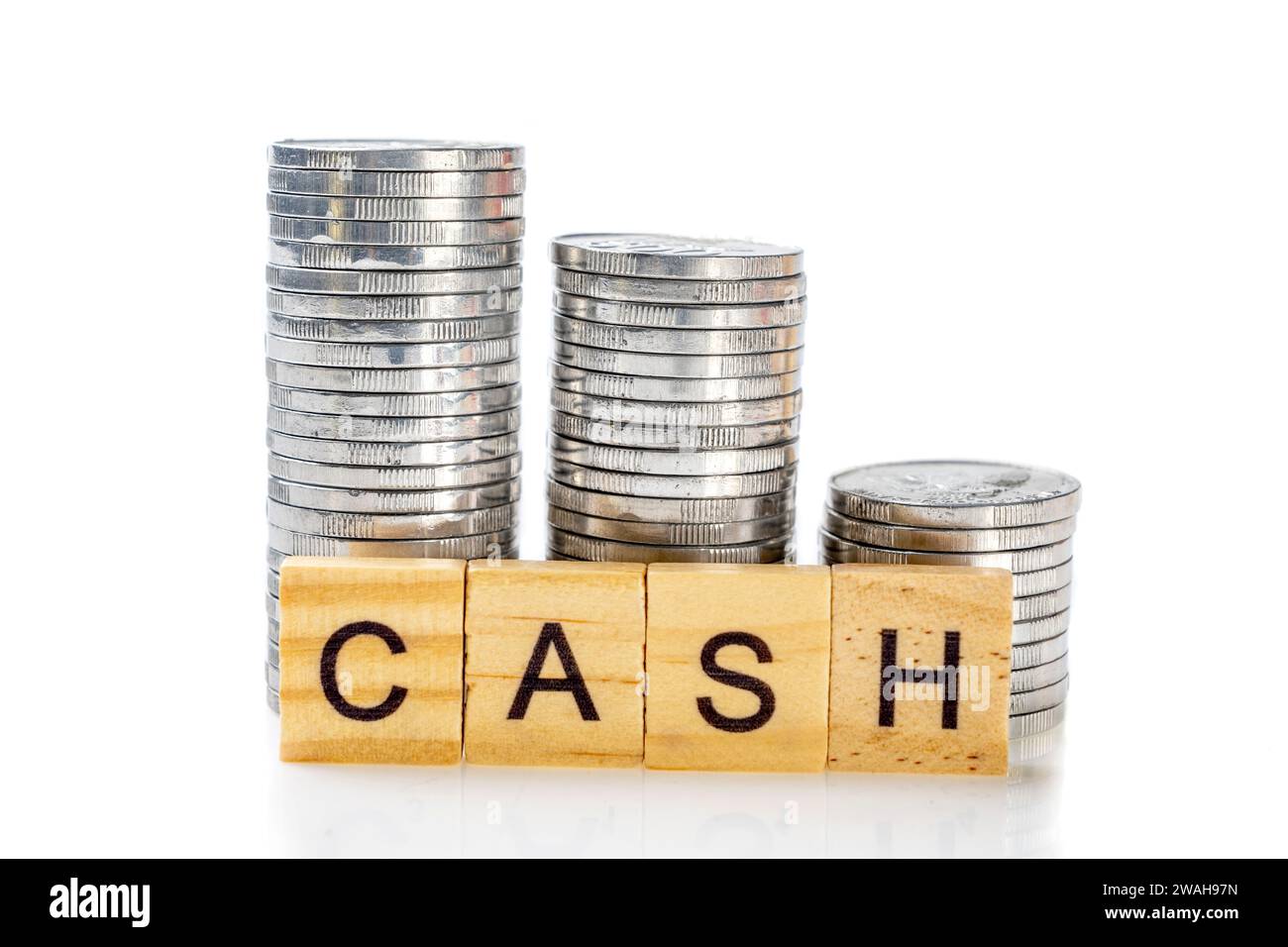Closeup view of a wooden cube with cash word and a stack of silver ...