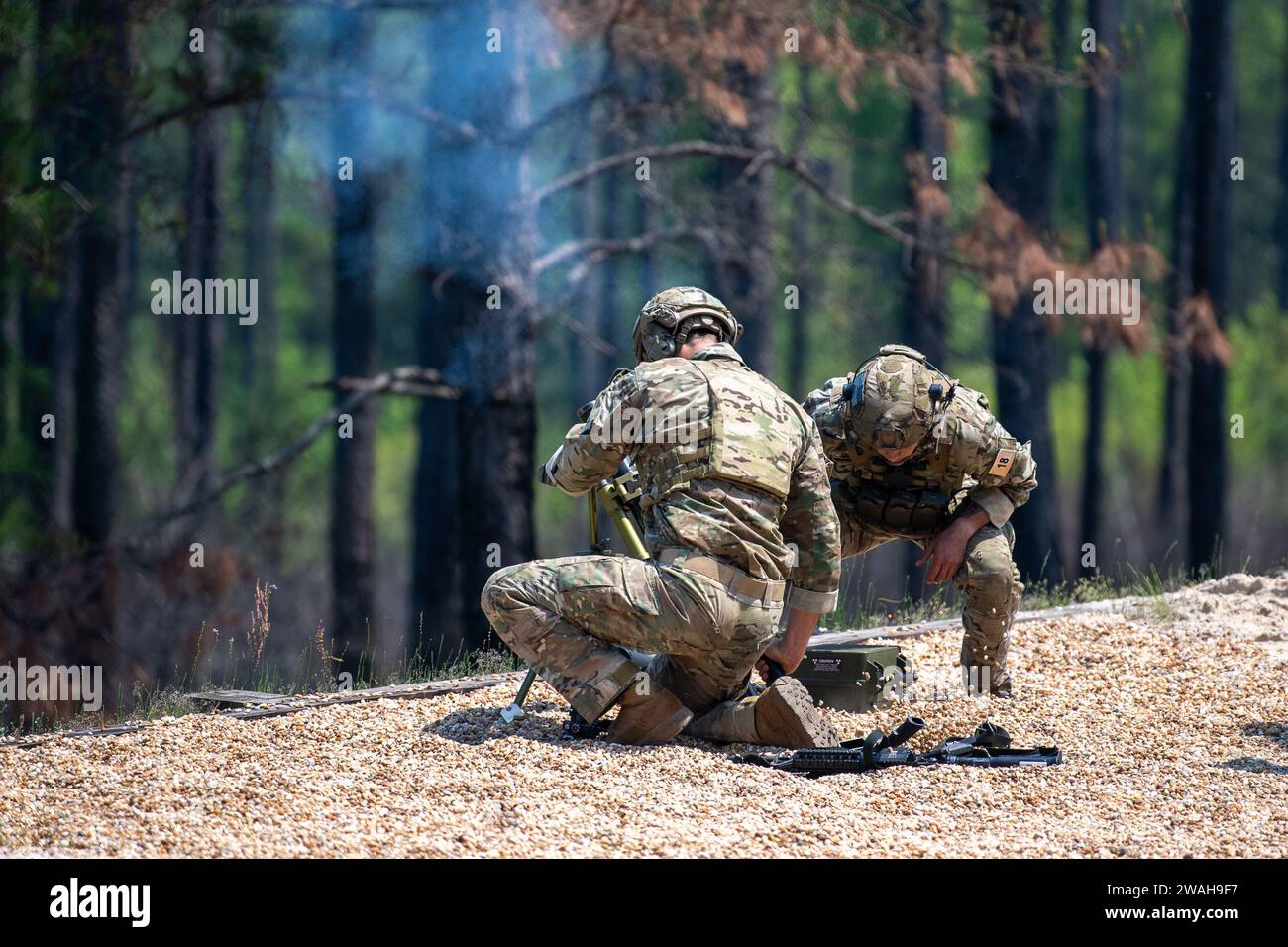 Soldiers aim and shoot a handheld and bipod-stabilized 60mm mortar ...