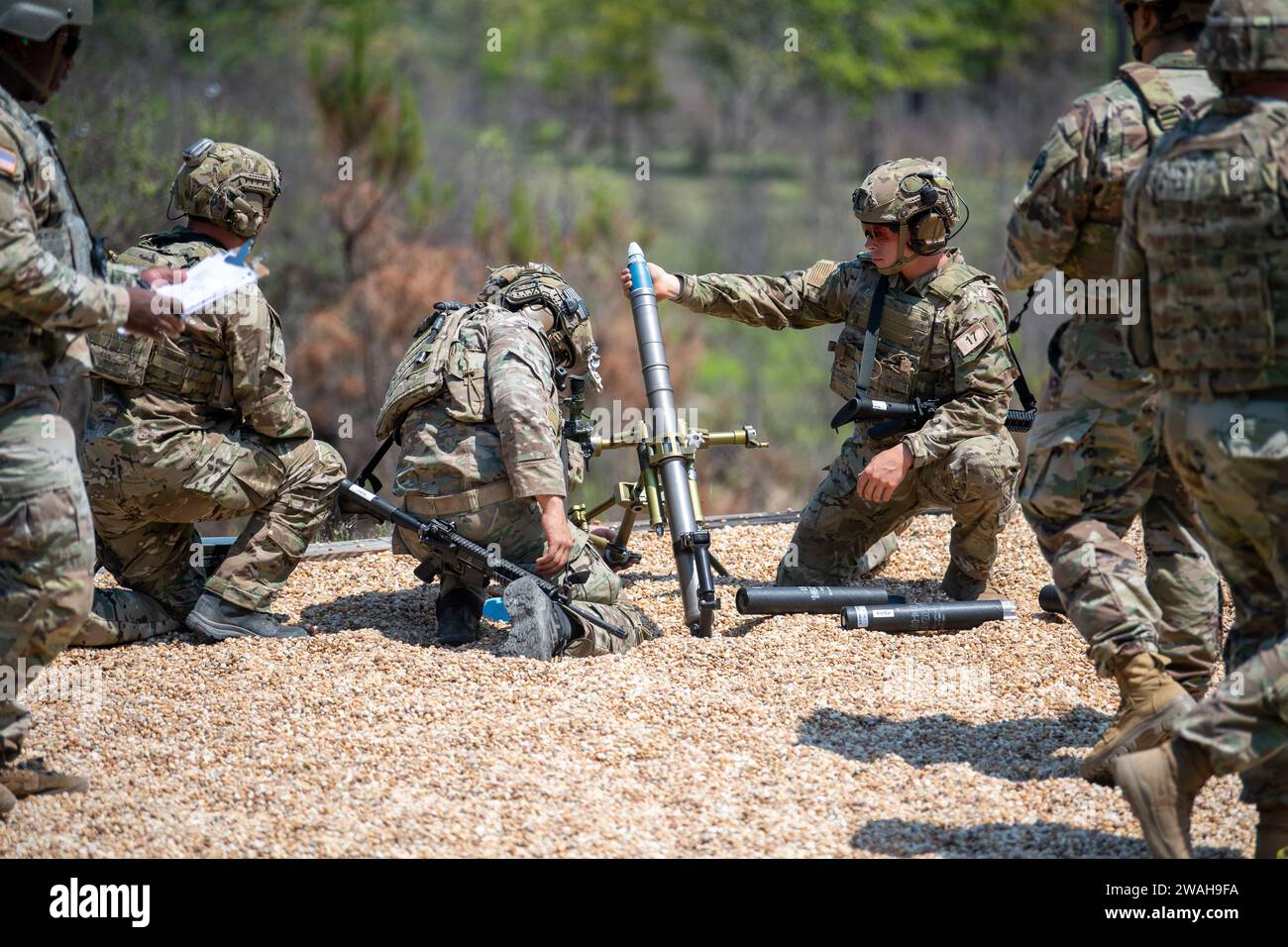 Soldiers aim and shoot a handheld and bipod-stabilized 60mm mortar ...