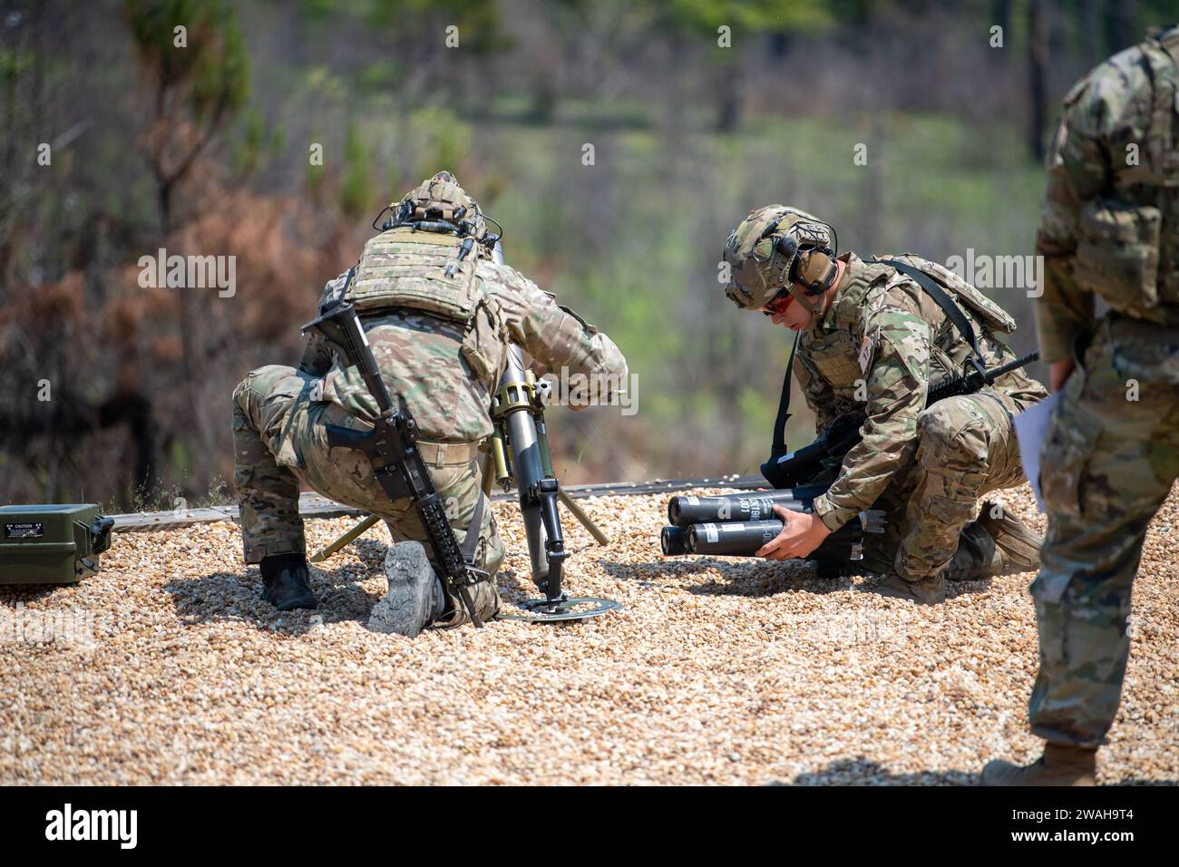 Soldiers aim and shoot a handheld and bipod-stabilized 60mm mortar ...