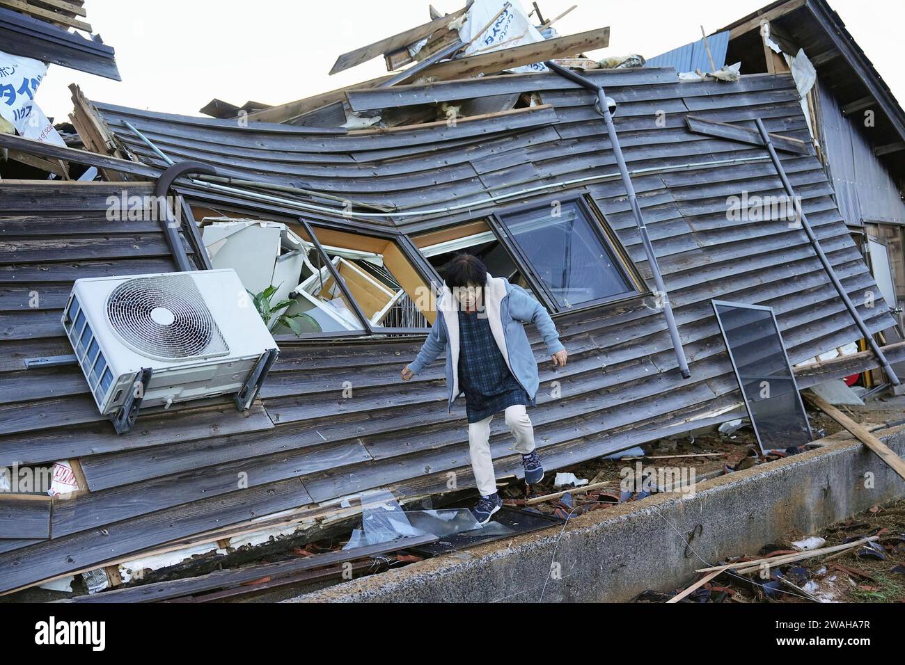 A resident checks her destroyed house in Wajima, Ishikawa prefecture ...