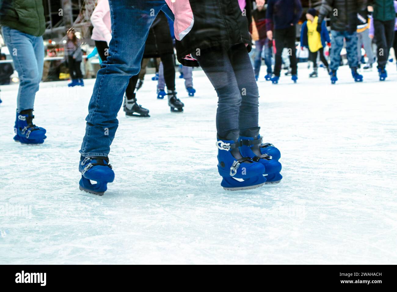 People standing on ice skates at the city skating arena enjoying the ...