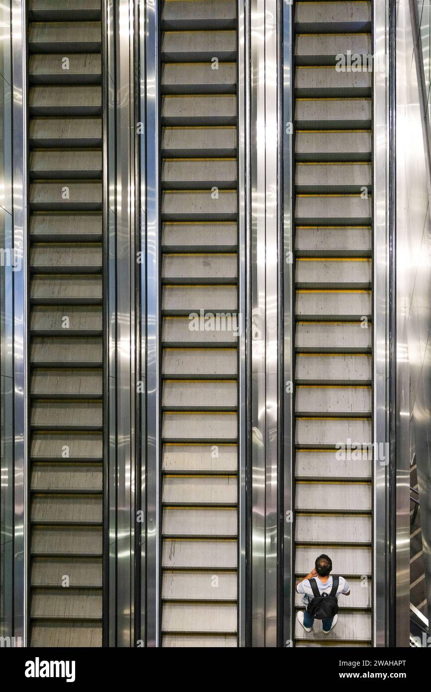 Men travelling up an escalator in Wynyard train station, Sydney, NSW ...