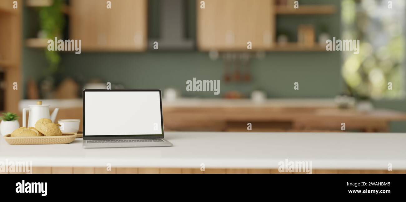A white-screen laptop computer on a white kitchen tabletop in a modern ...