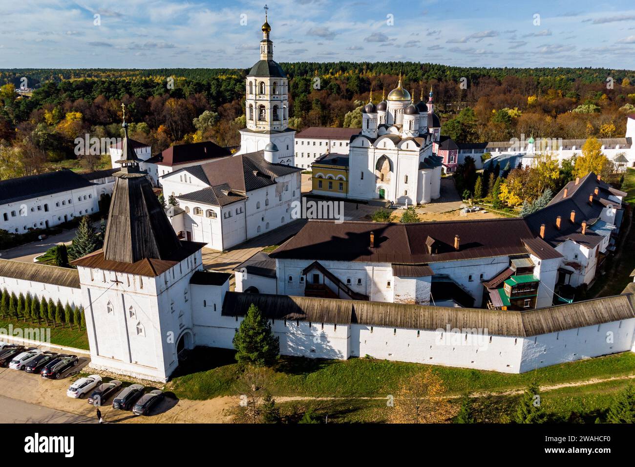 Landscape view of a picturesque medieval Orthodox monastery with white walls and towers ...