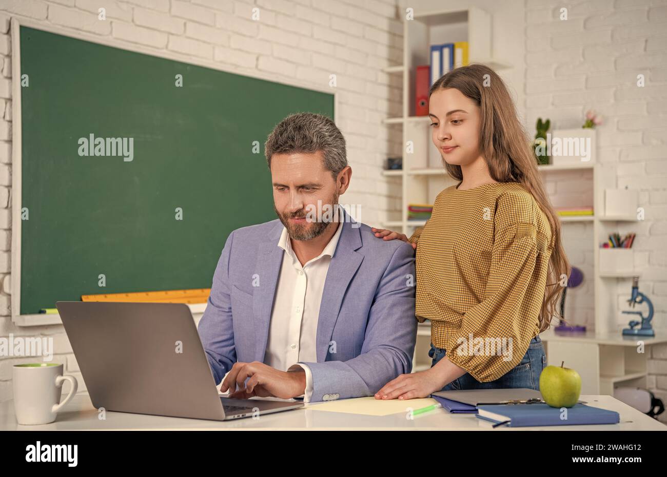 curious teen kid with man teacher in classroom. education Stock Photo ...