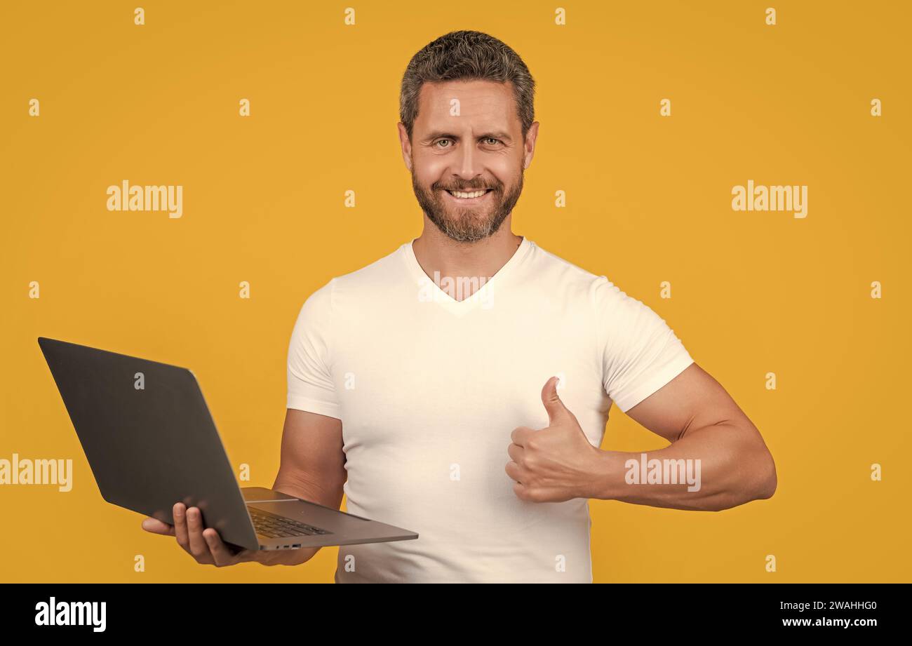 man programmer with laptop show thumb up isolated on yellow background. man programmer Stock ...
