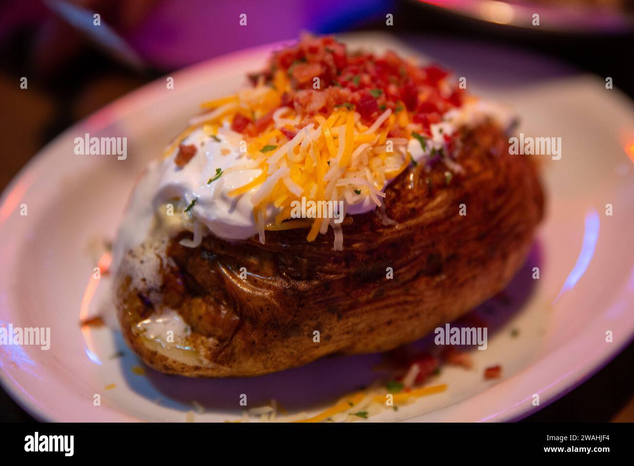 Fully loaded baked potato as a side Stock Photo - Alamy
