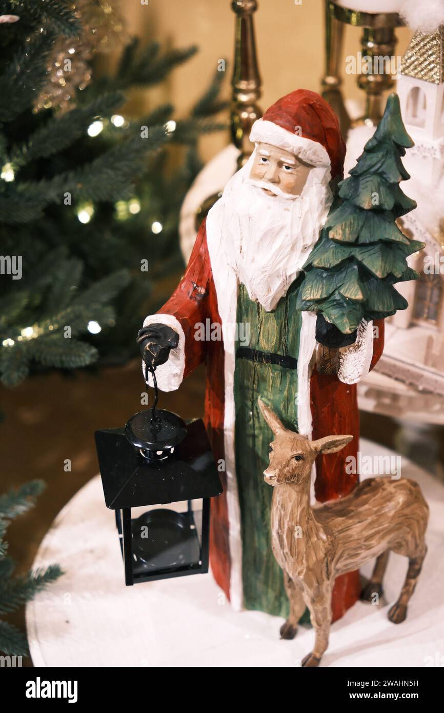 An image of a festive Santa figurine holding a miniature evergreen ...