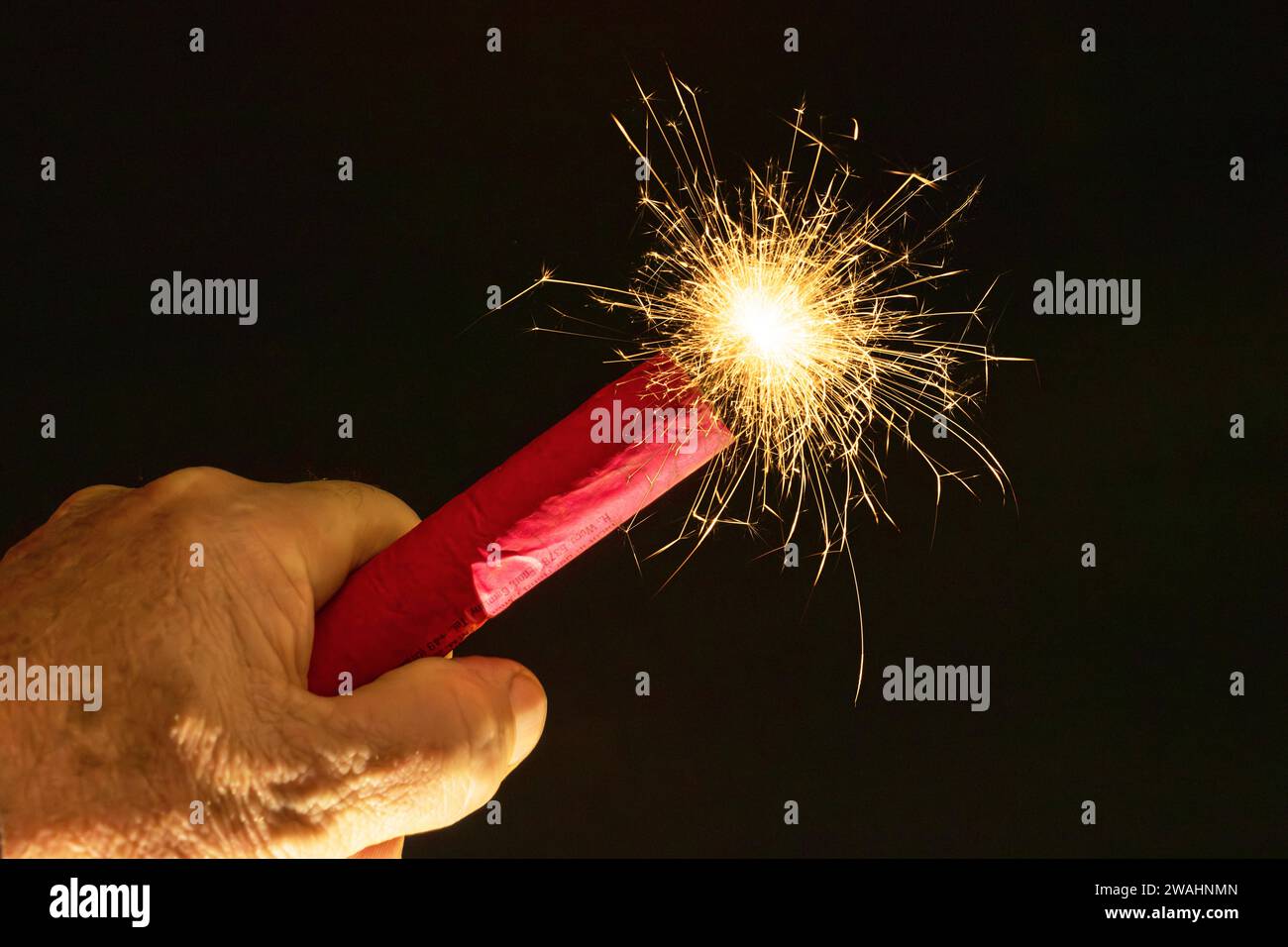 Ignited firework is held by one hand, firecracker, firecracker with ...