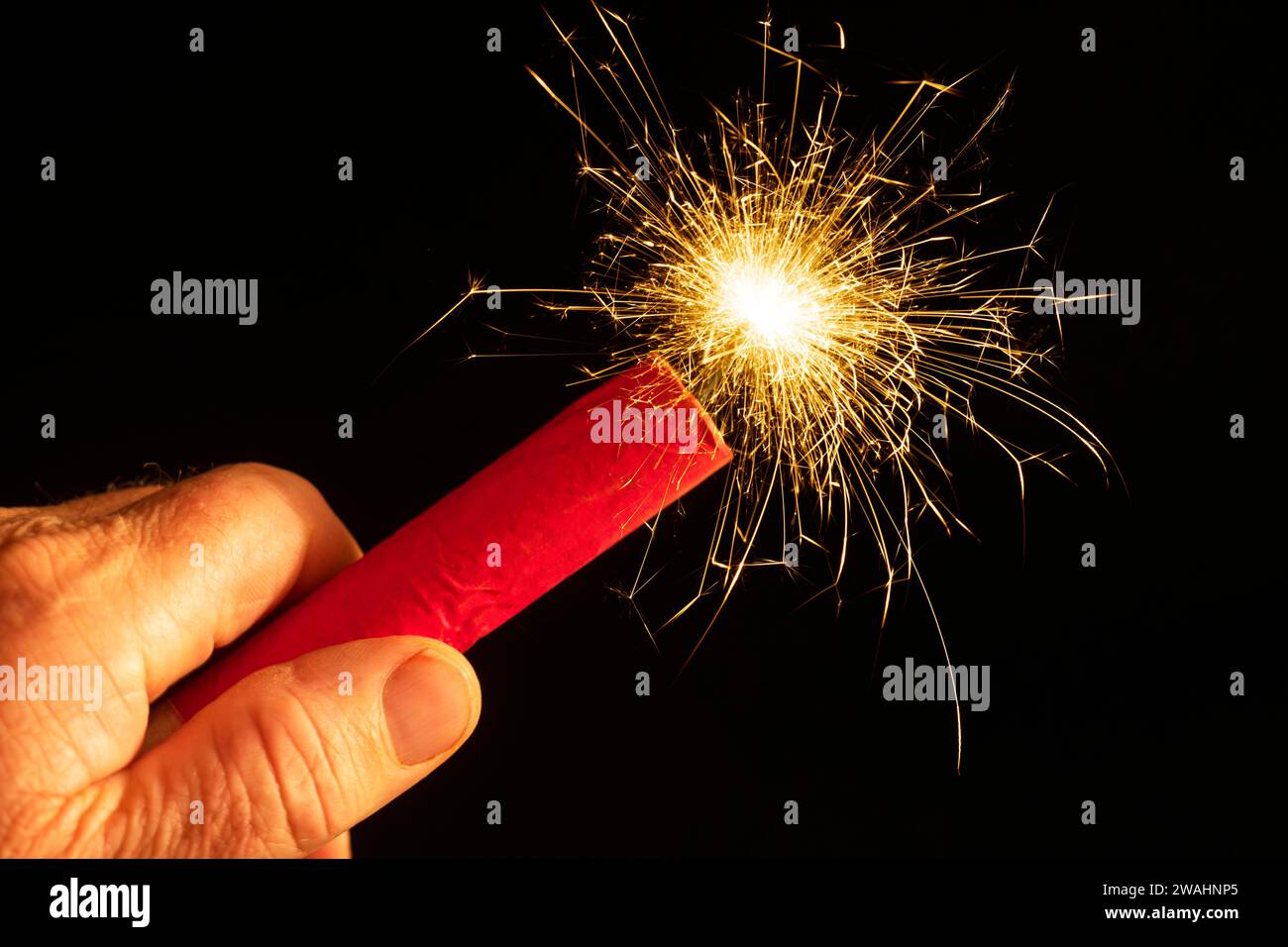 Ignited firework is held by one hand, firecracker, firecracker with ...